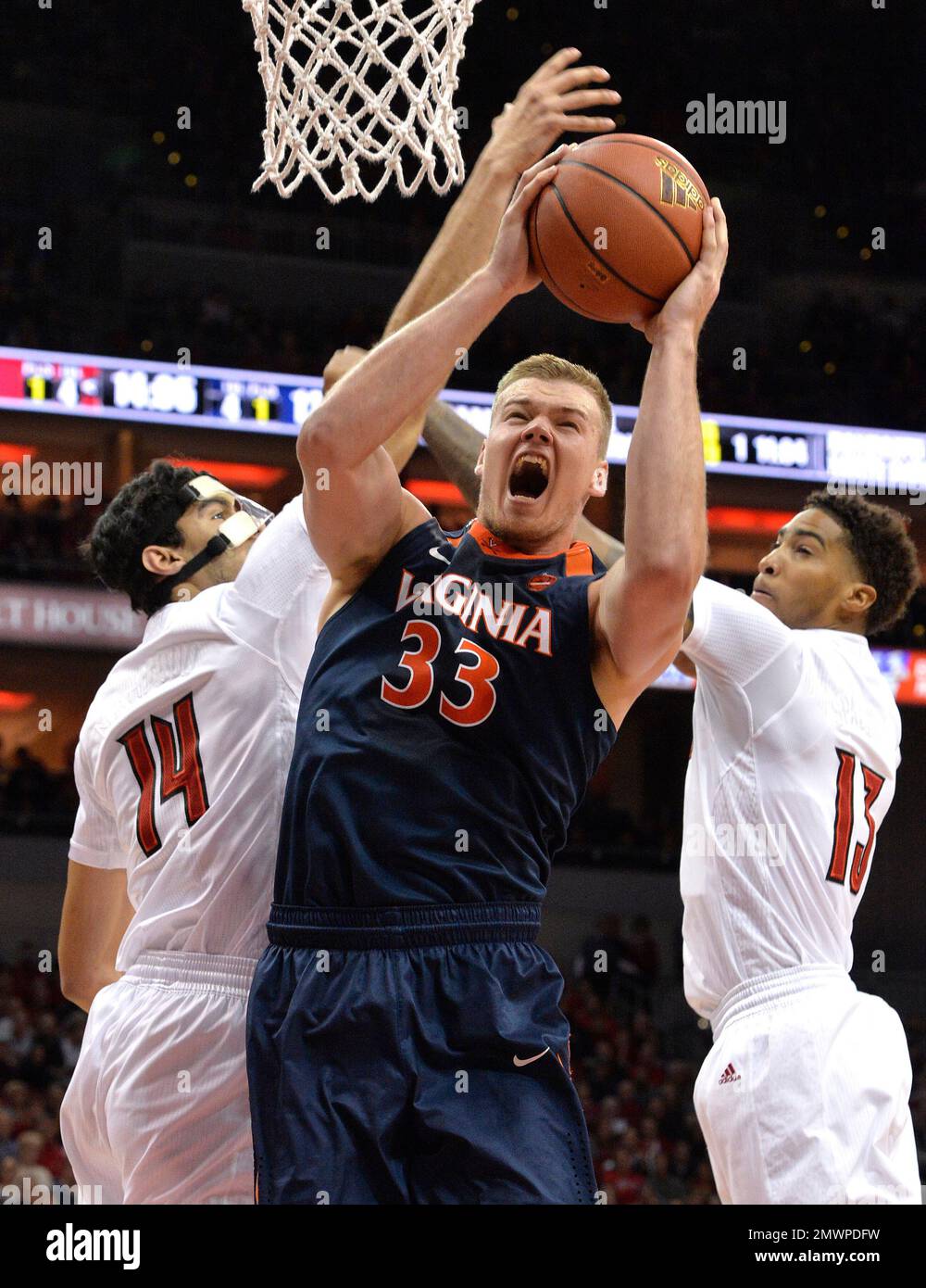Virginia's Jack Salt (33) shoots through the defense of Louisville's ...