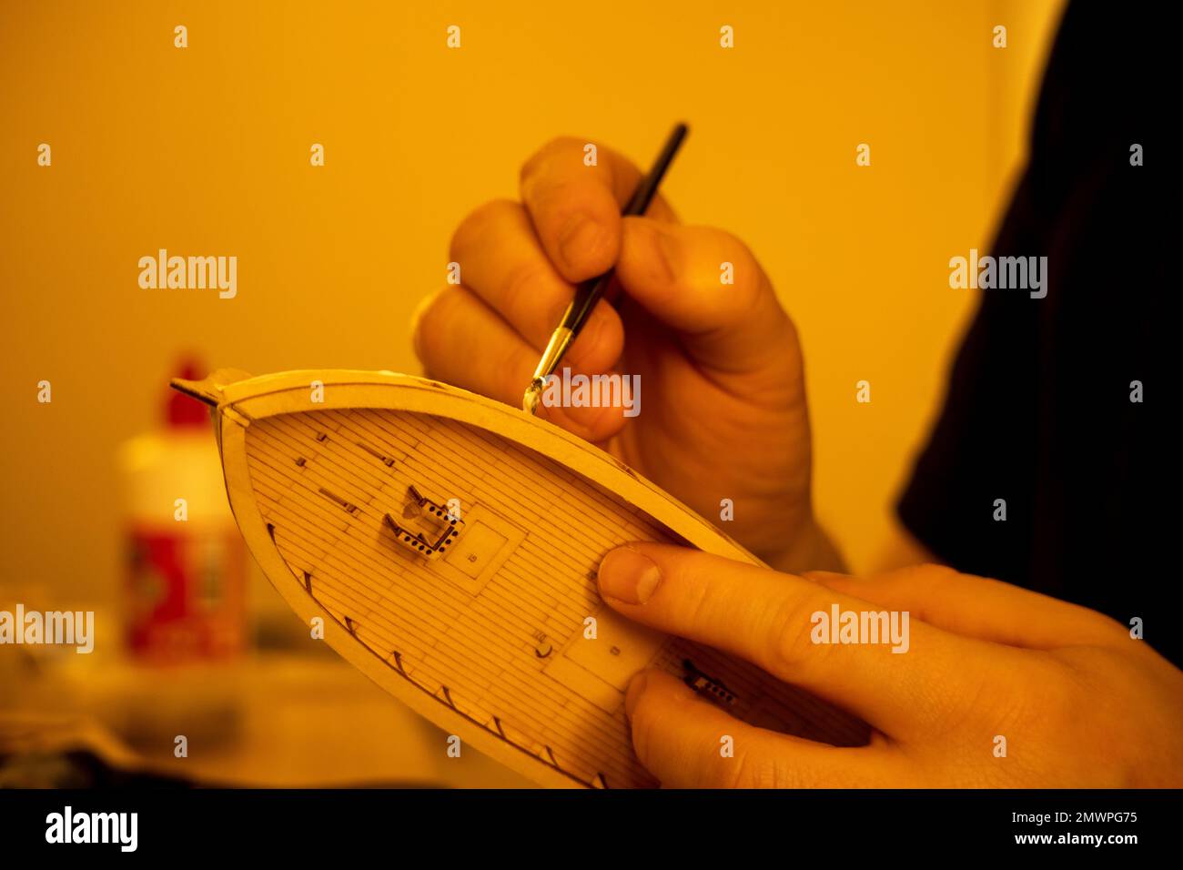 Painting a model of a wooden ship Stock Photo - Alamy