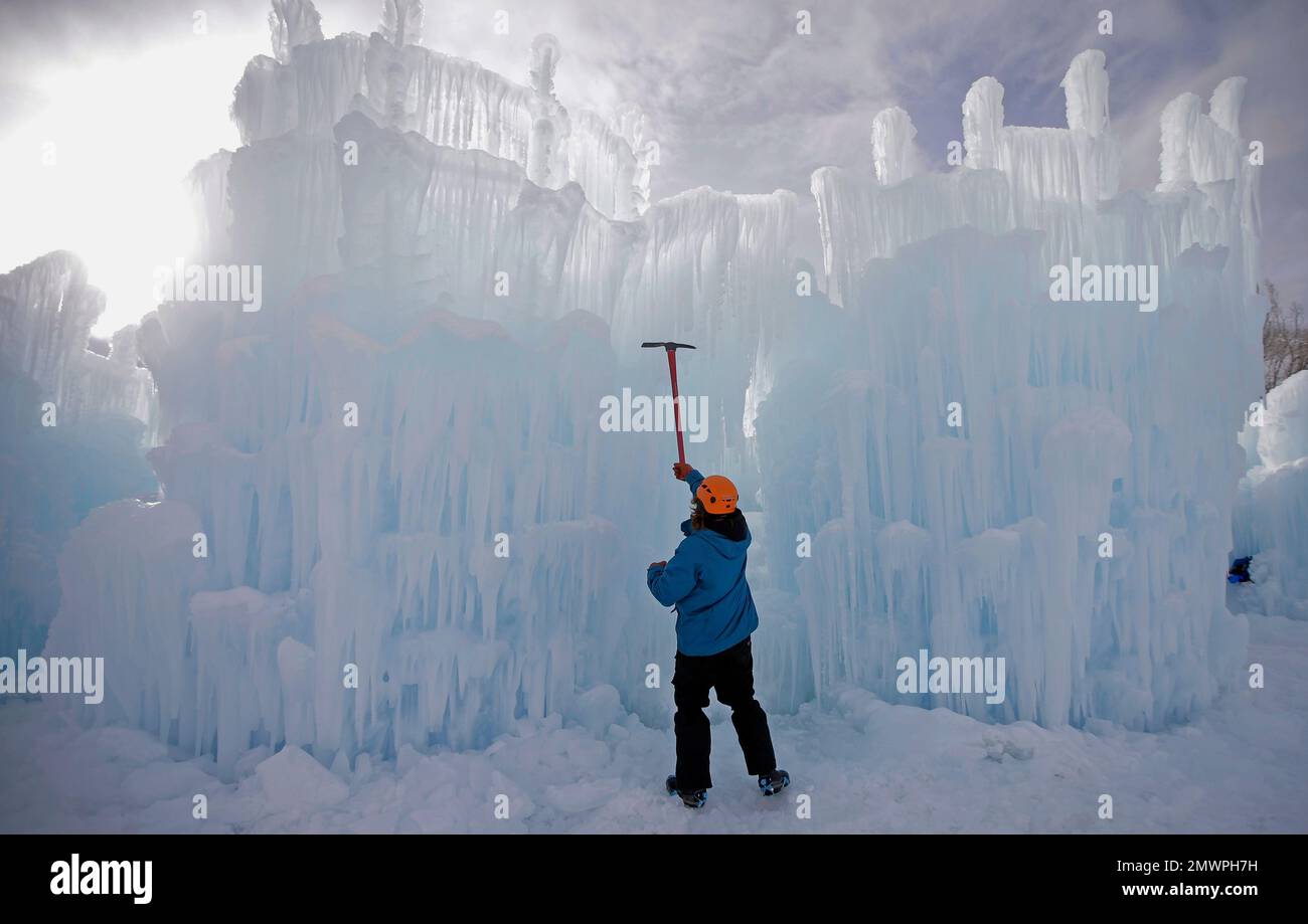 A worker helps sculpt during final preparations at the Ice Castles ...