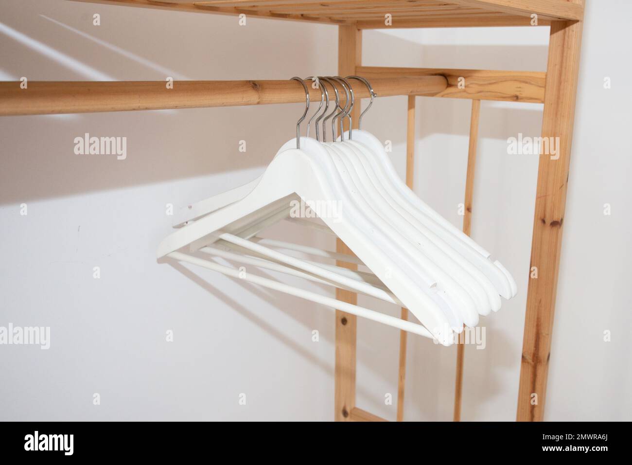 several empty white hangers on the wooden carrying clothes hangars ...