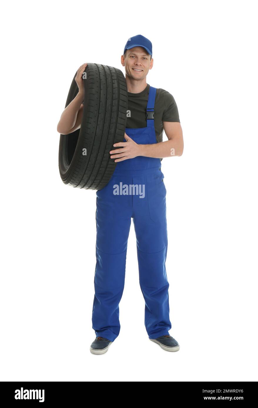 Full length portrait of professional auto mechanic with tire on white ...