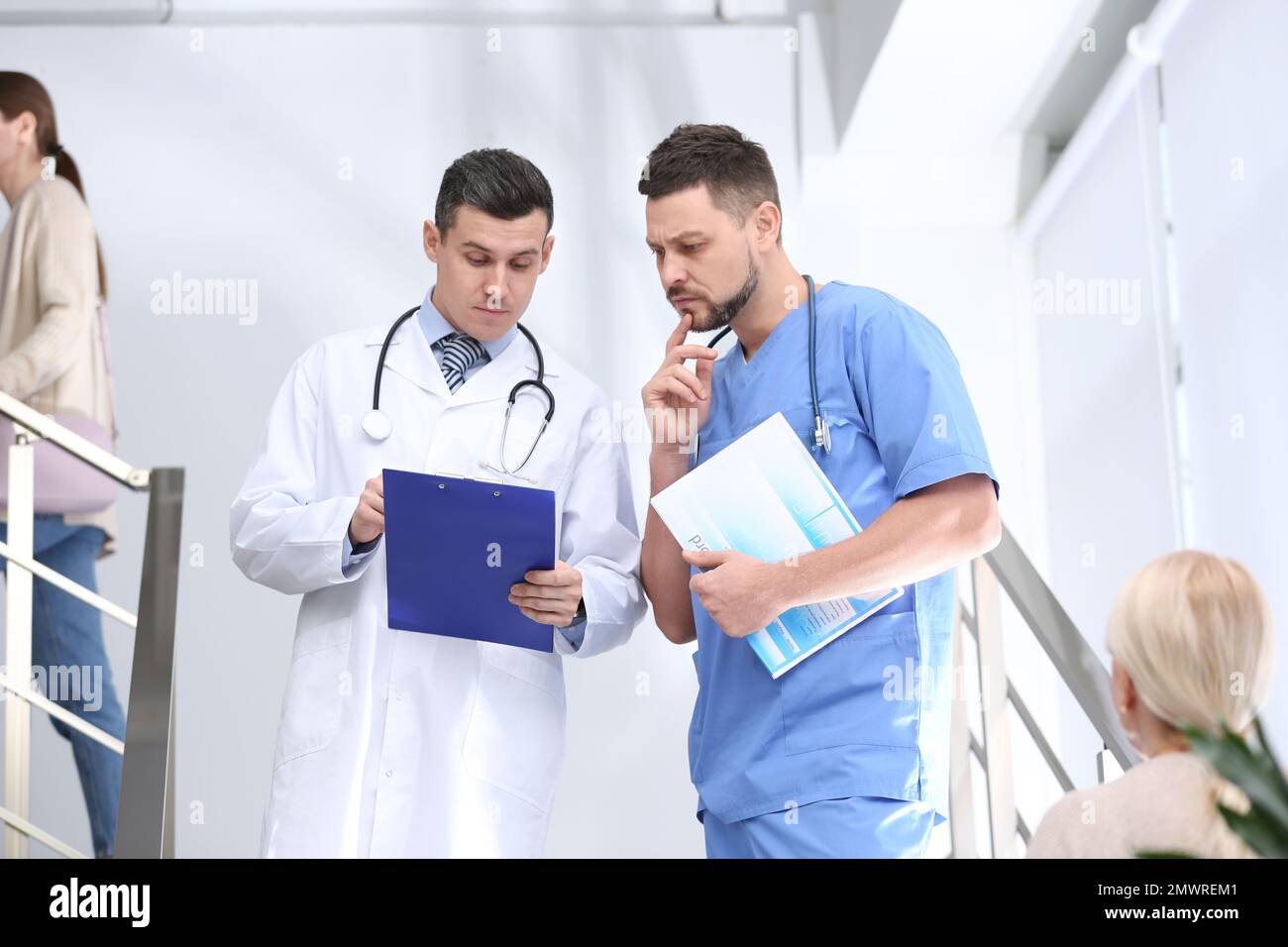 Doctors discussing patient's diagnosis on stairs in hospital Stock ...