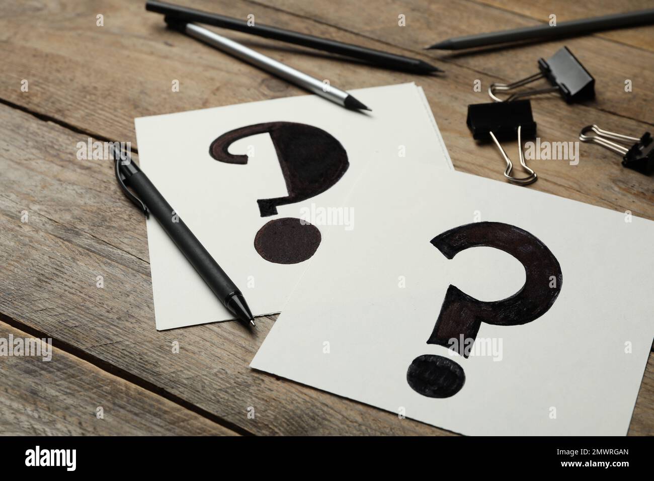 Notes with question marks and pen on wooden table, closeup Stock Photo ...