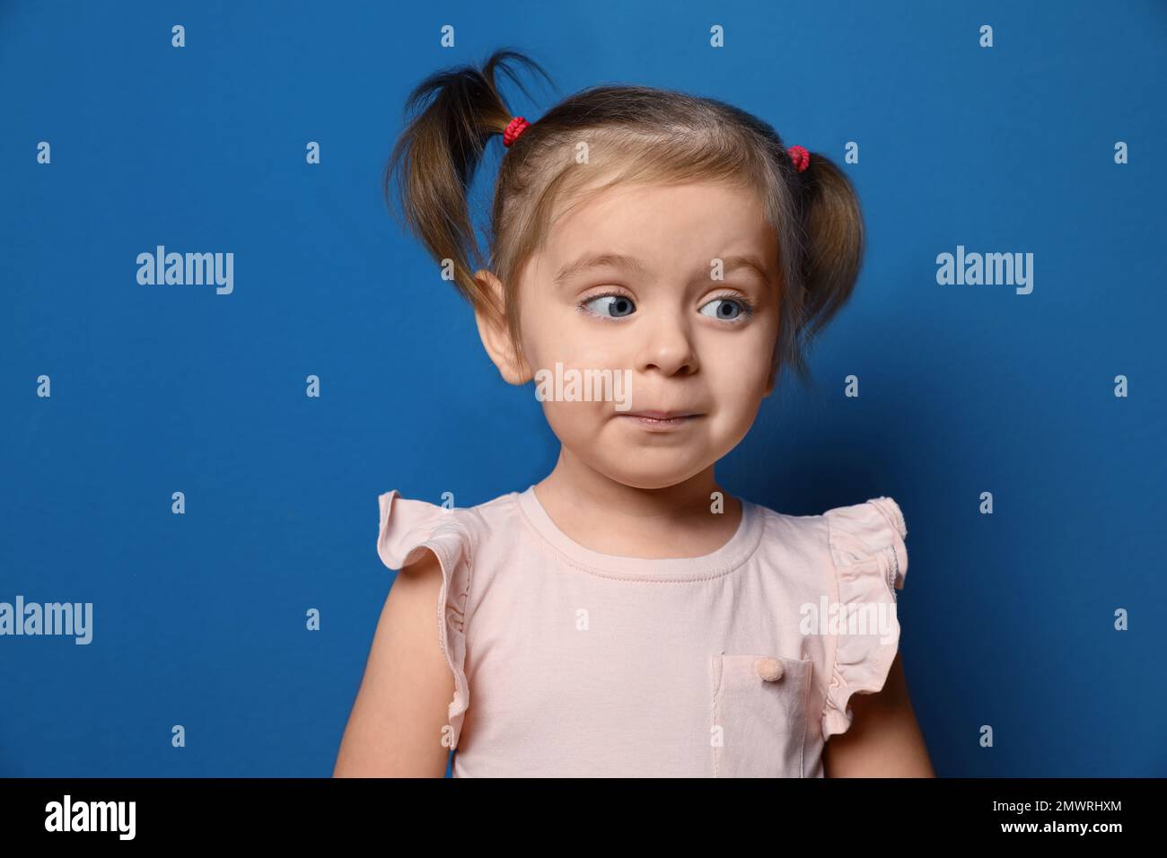 Portrait of cute little girl on blue background Stock Photo - Alamy