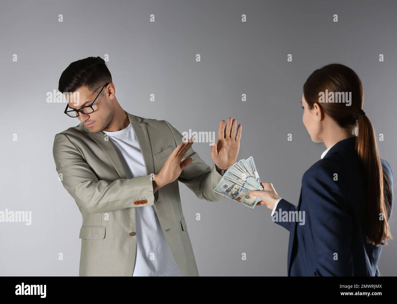 Man refusing to take bribe on grey background Stock Photo - Alamy