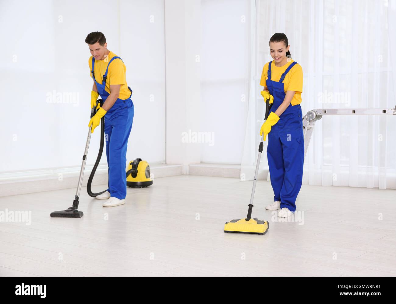 Team of professional janitors cleaning room after renovation Stock ...