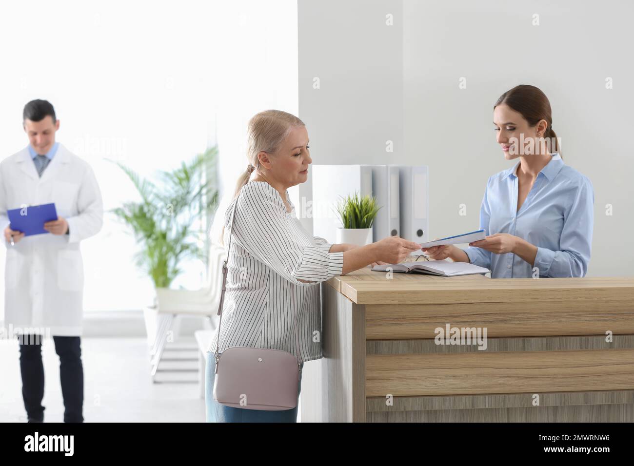 Patient taking her medical record before doctor's appointment in ...