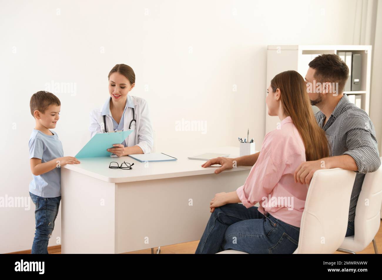Parents and son visiting pediatrician. Doctor working with patient in ...