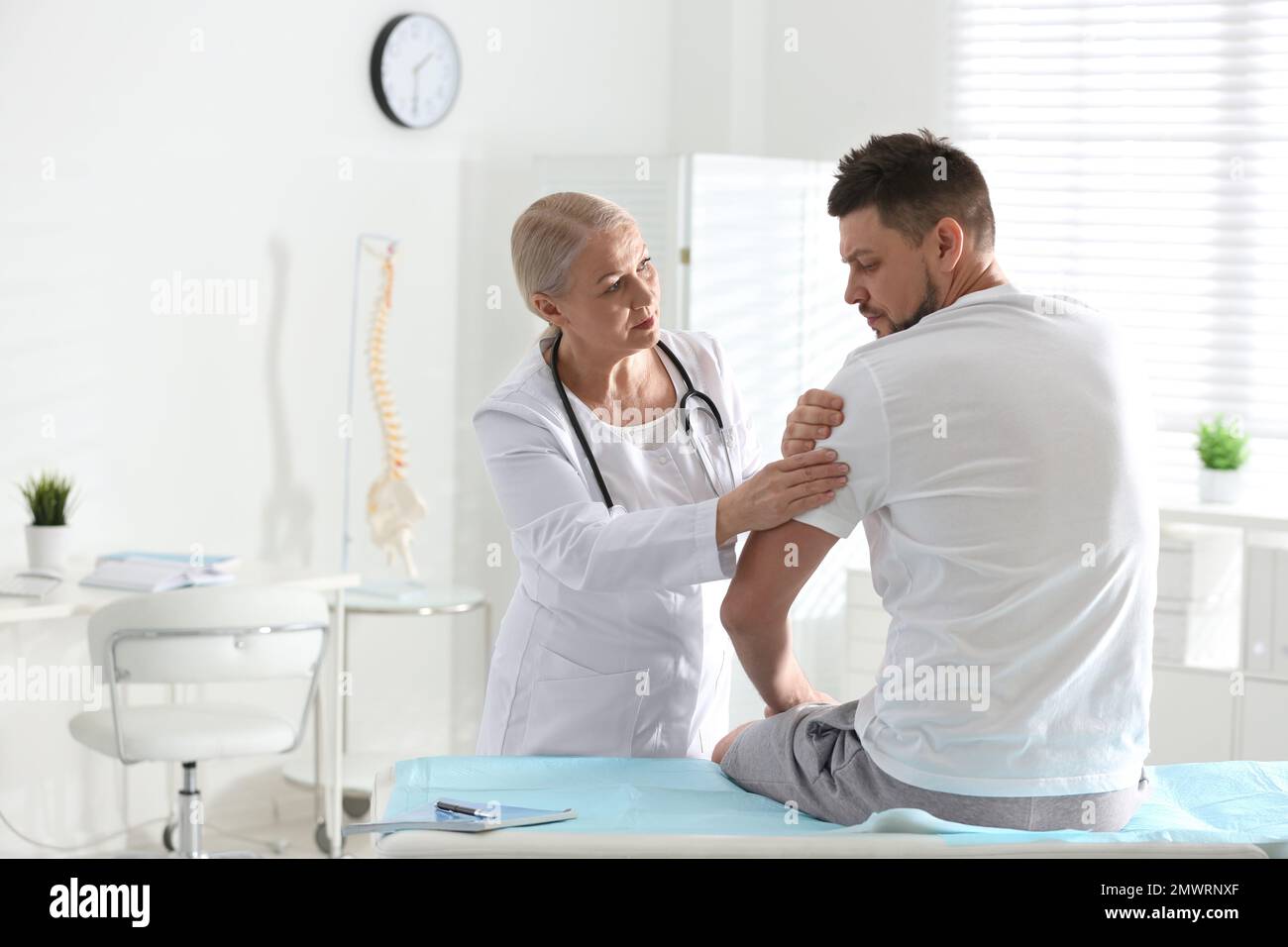Doctor examining injured shoulder hi-res stock photography and images ...
