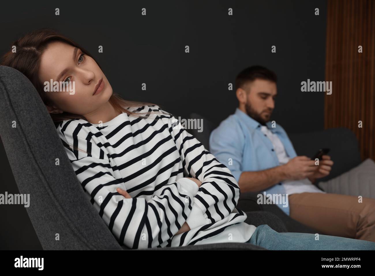 Man preferring smartphone over his girlfriend at home, focus on woman ...