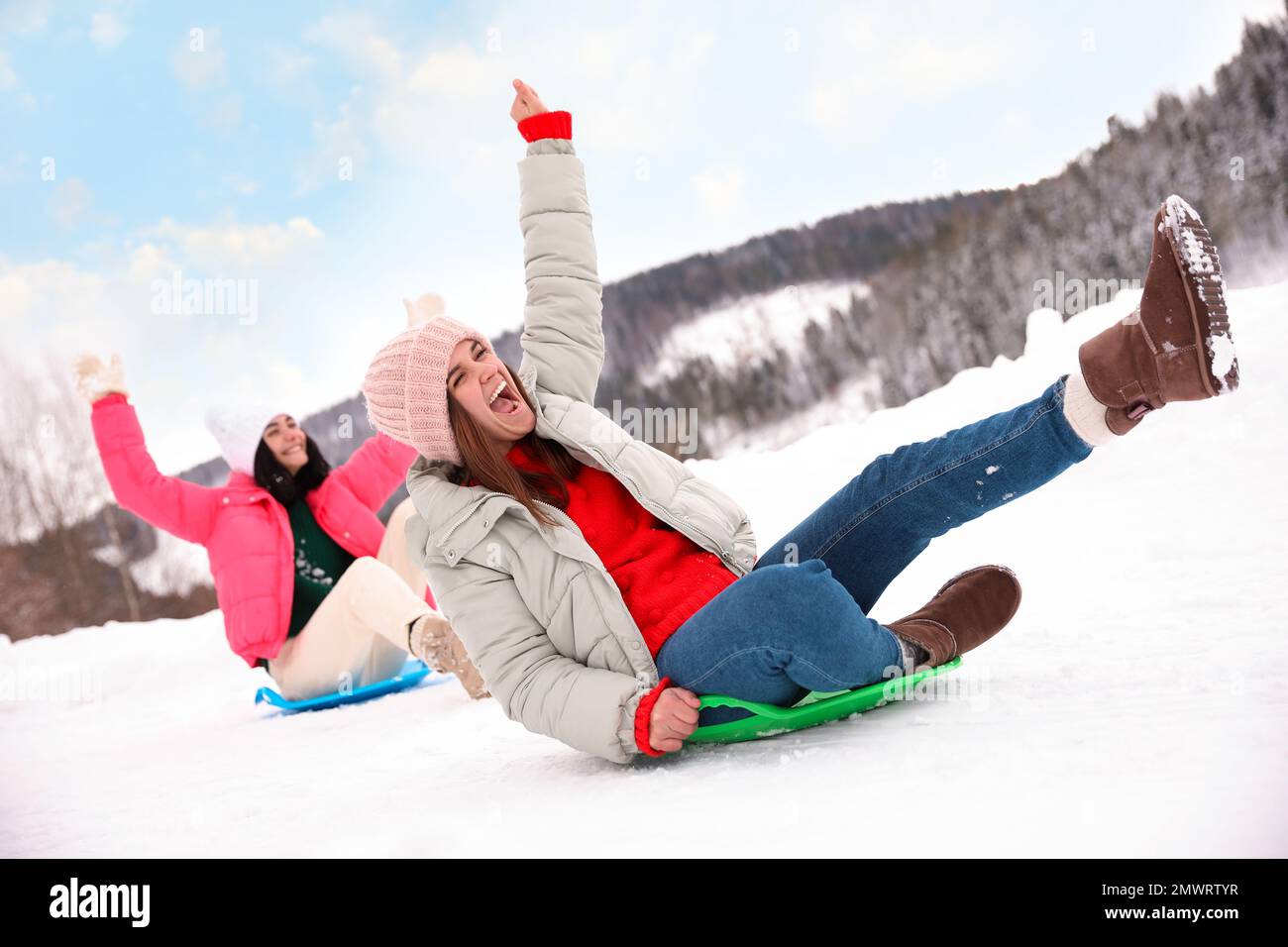 Happy friends having fun and sledding on snow. Winter vacation Stock ...
