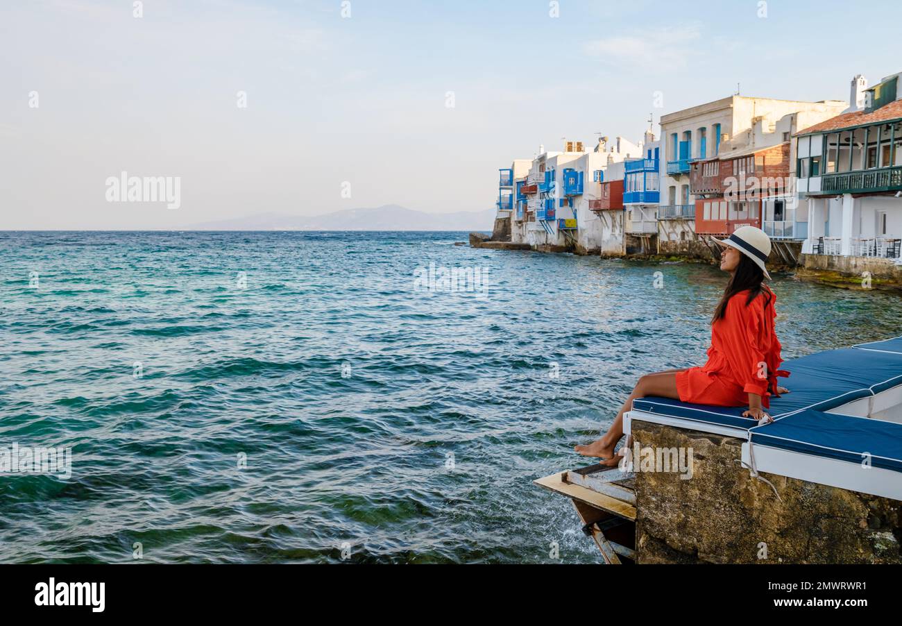Young women on the street of Mykonos Greek village in Greece, colorful ...