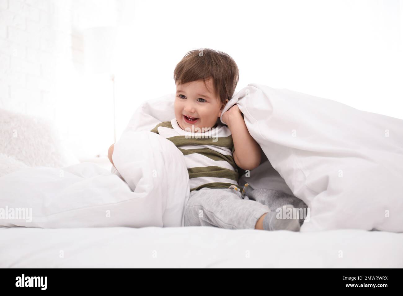 Cute little child playing under blanket in bed Stock Photo - Alamy