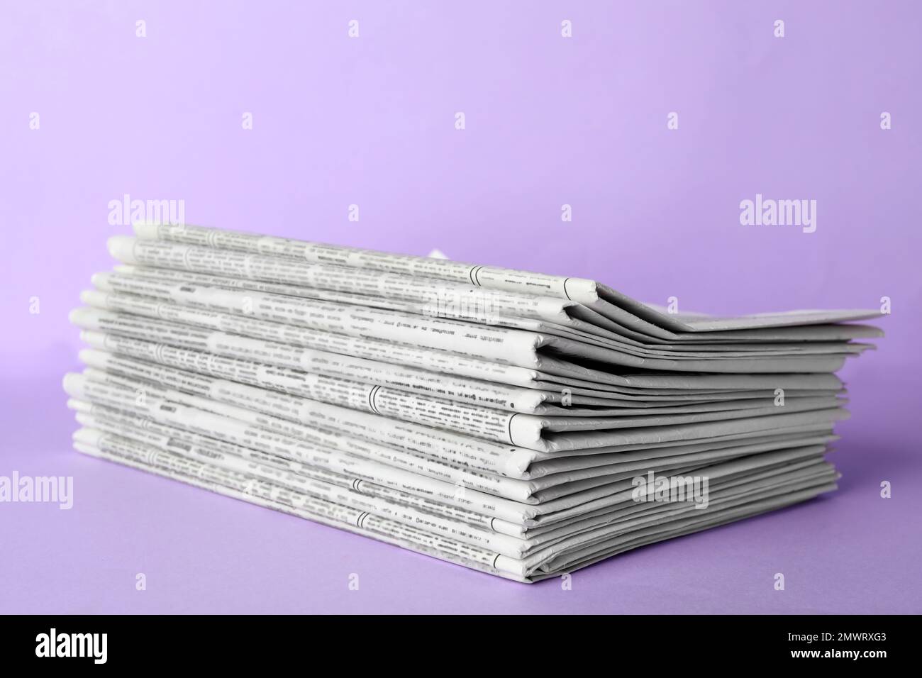 Stack of newspapers on light violet background. Journalist's work Stock ...