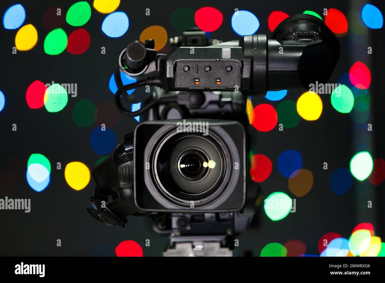 Modern video camera against blurred colorful lights Stock Photo - Alamy