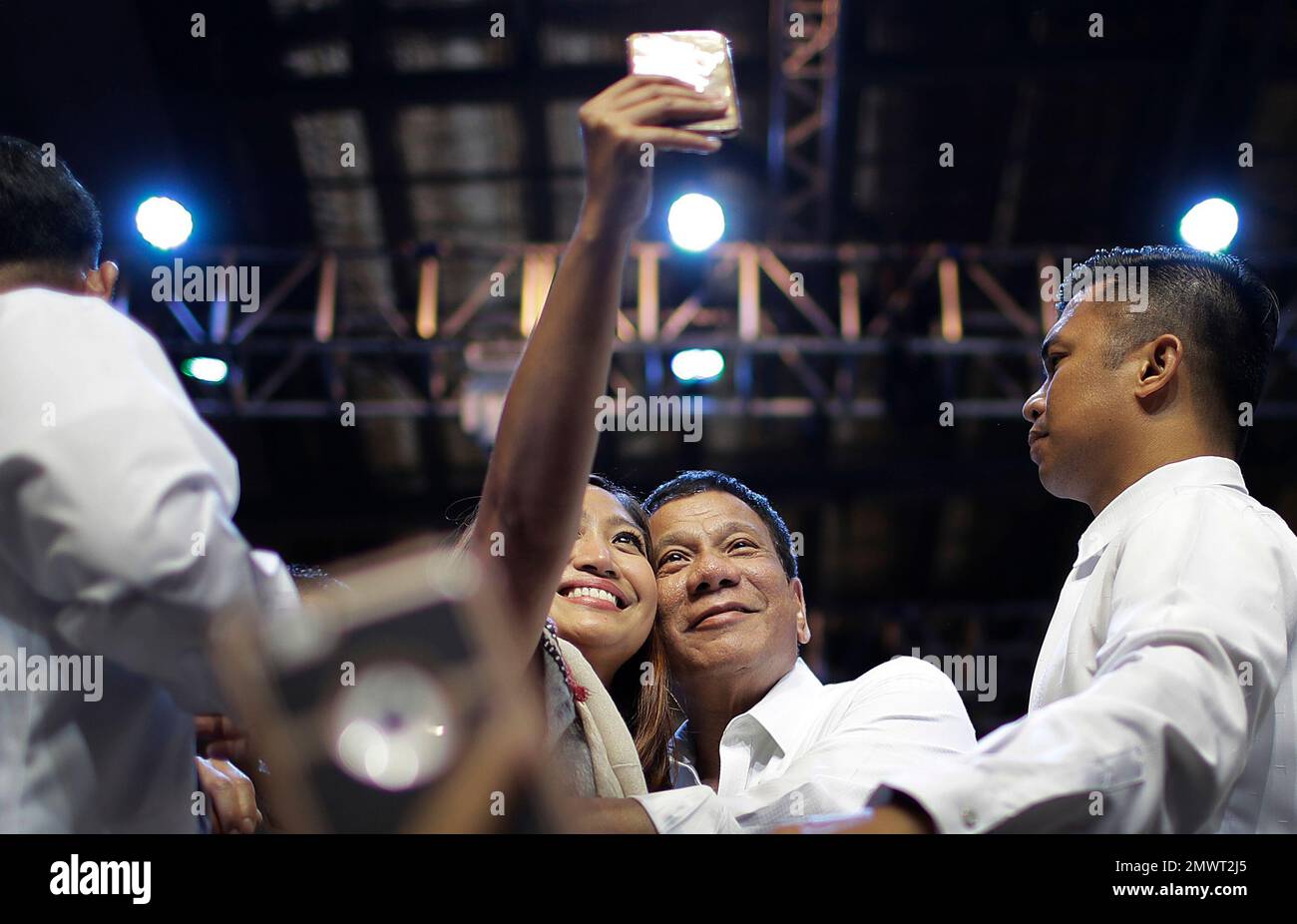 Philippine President Rodrigo Duterte, center, takes a selfie with a ...