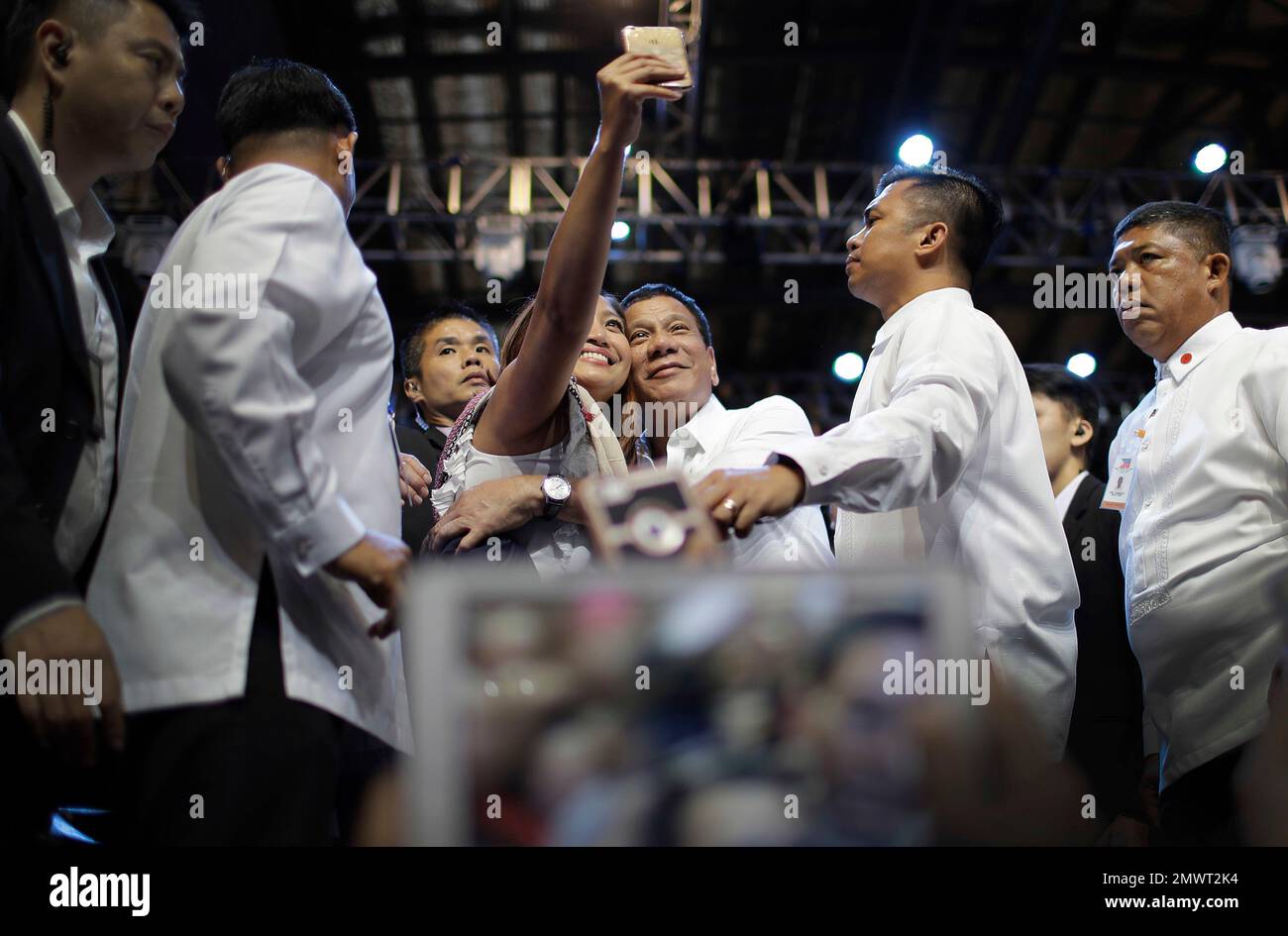 Philippine President Rodrigo Duterte, center, takes a selfie with a ...
