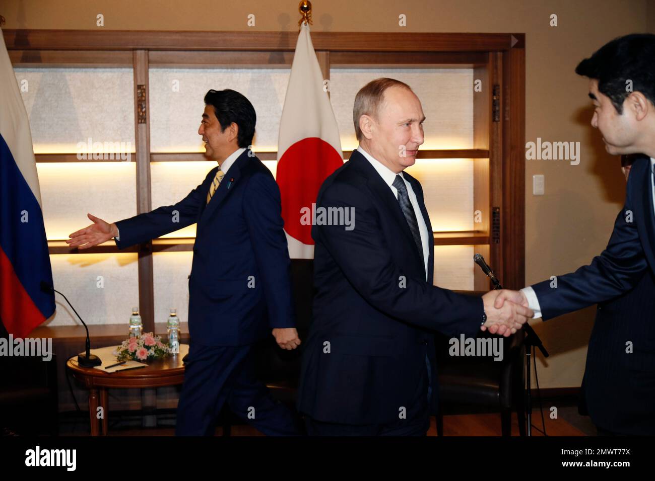 Russian President Vladimir Putin, center, shakes hands with a Japanese ...