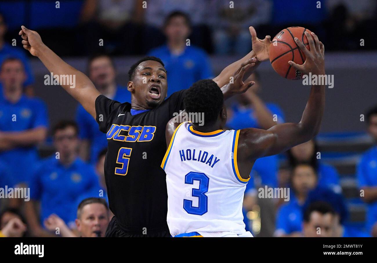 UCLA guard Aaron Holiday, right, shoots as UC Santa Barbara forward ...
