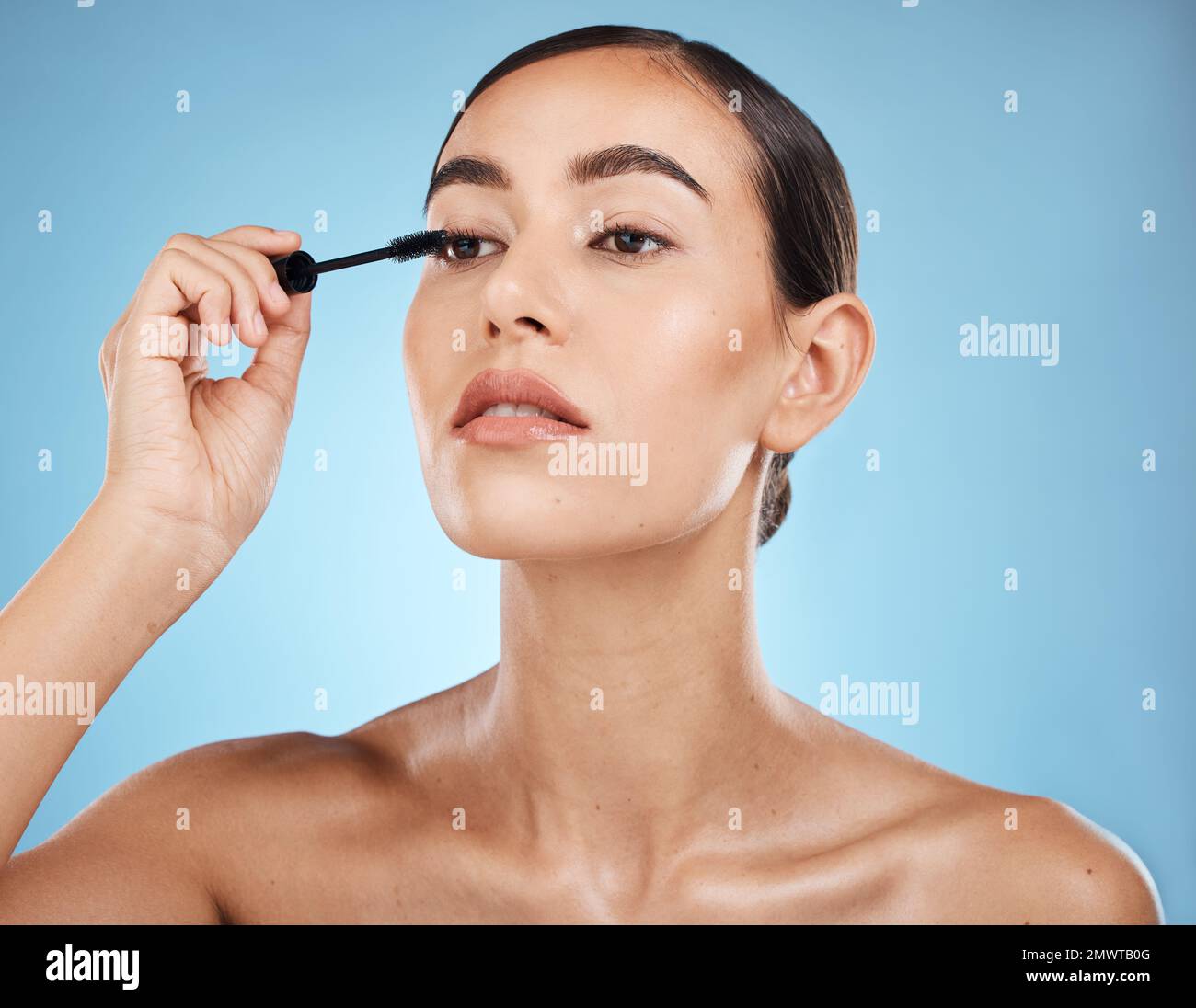 Mascara, application and woman with makeup on face isolated on a blue ...