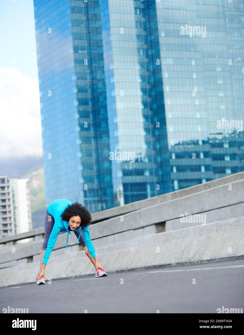 Prepping for an early run. a young female jogger stretching on the ...