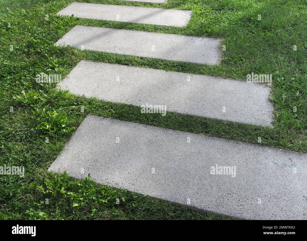 grey concrete tiles path in the grass Stock Photo - Alamy