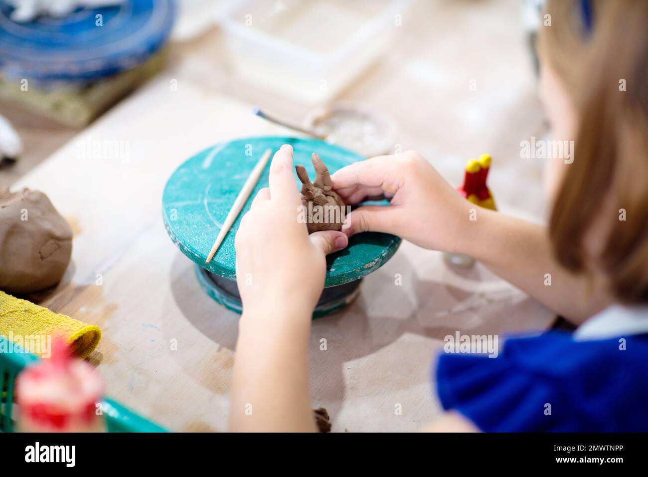 Child working on pottery wheel. Kids arts and crafts class in workshop ...