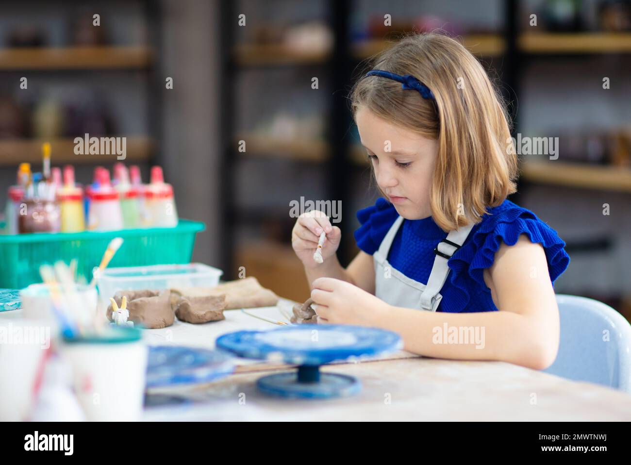 Child working on pottery wheel. Kids arts and crafts class in workshop ...