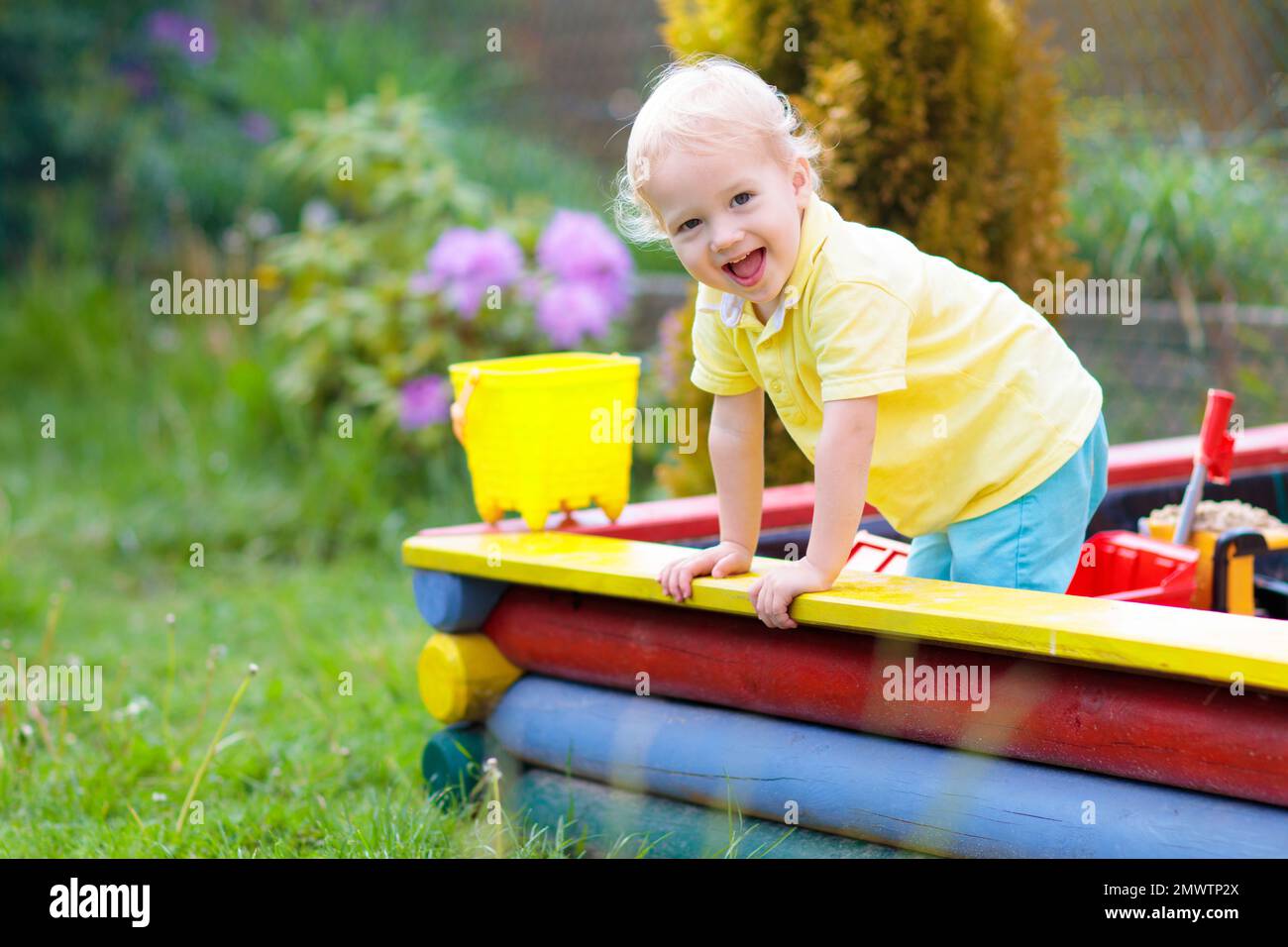 Child in sand box. Kid playing with sand on colorful playground. Active ...