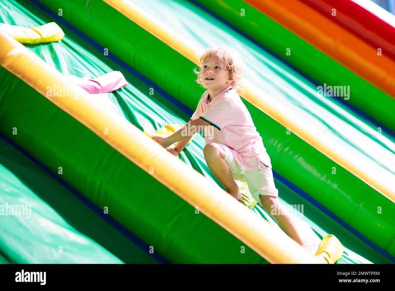 Child jumping on colorful playground trampoline. Kids jump in ...