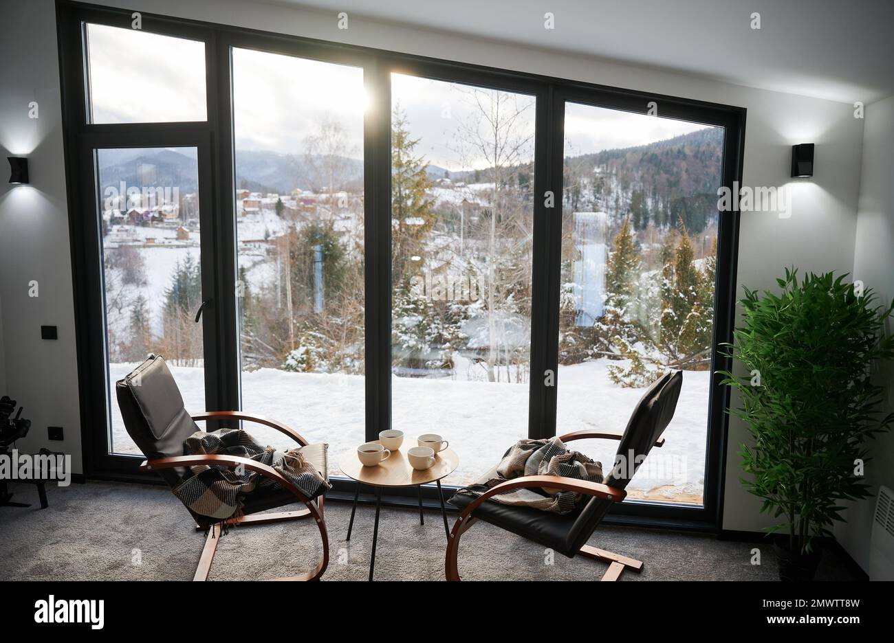 Cozy room with small coffee table and armchairs in front of large ...