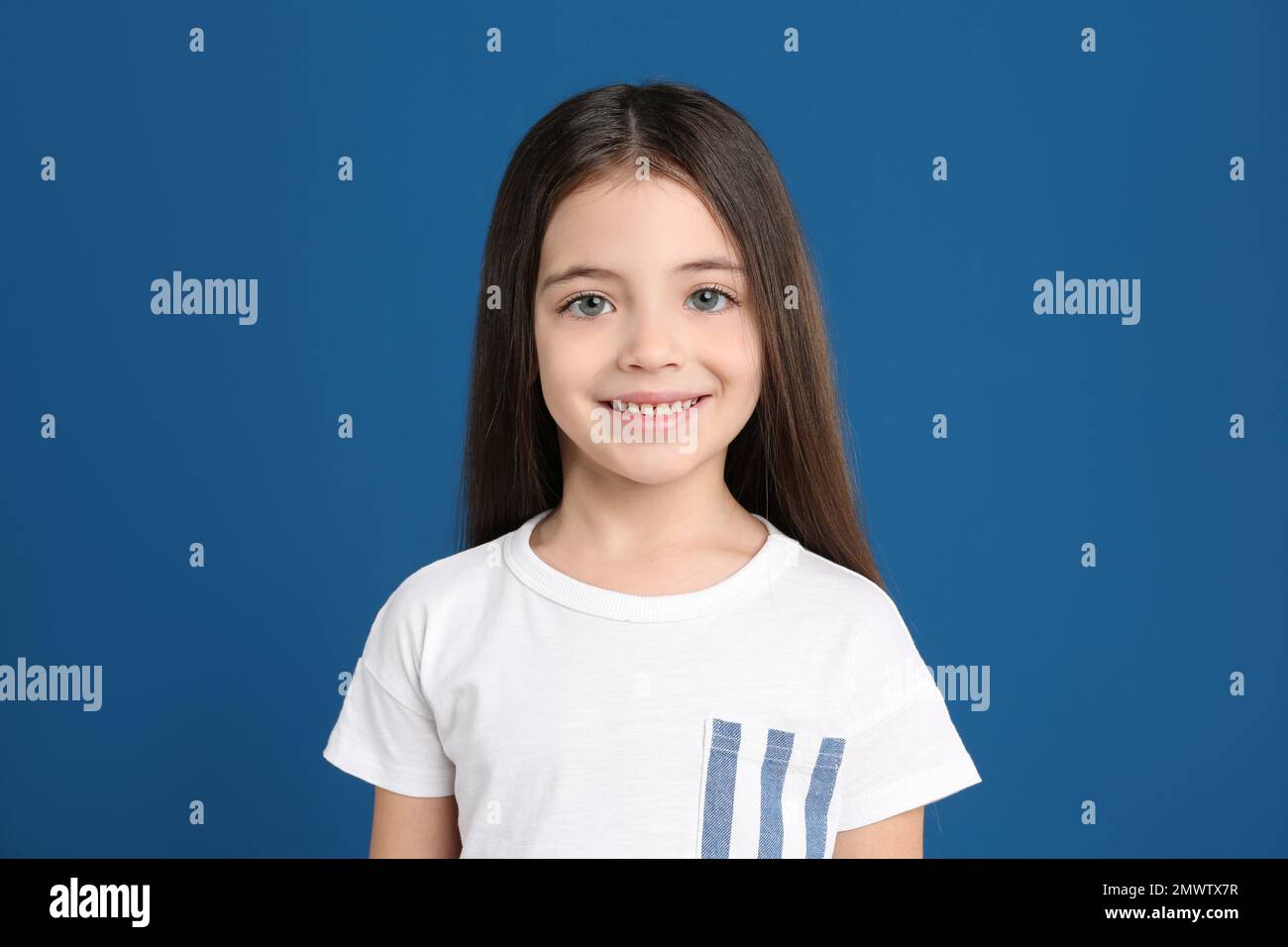Portrait of cute little girl on blue background Stock Photo - Alamy