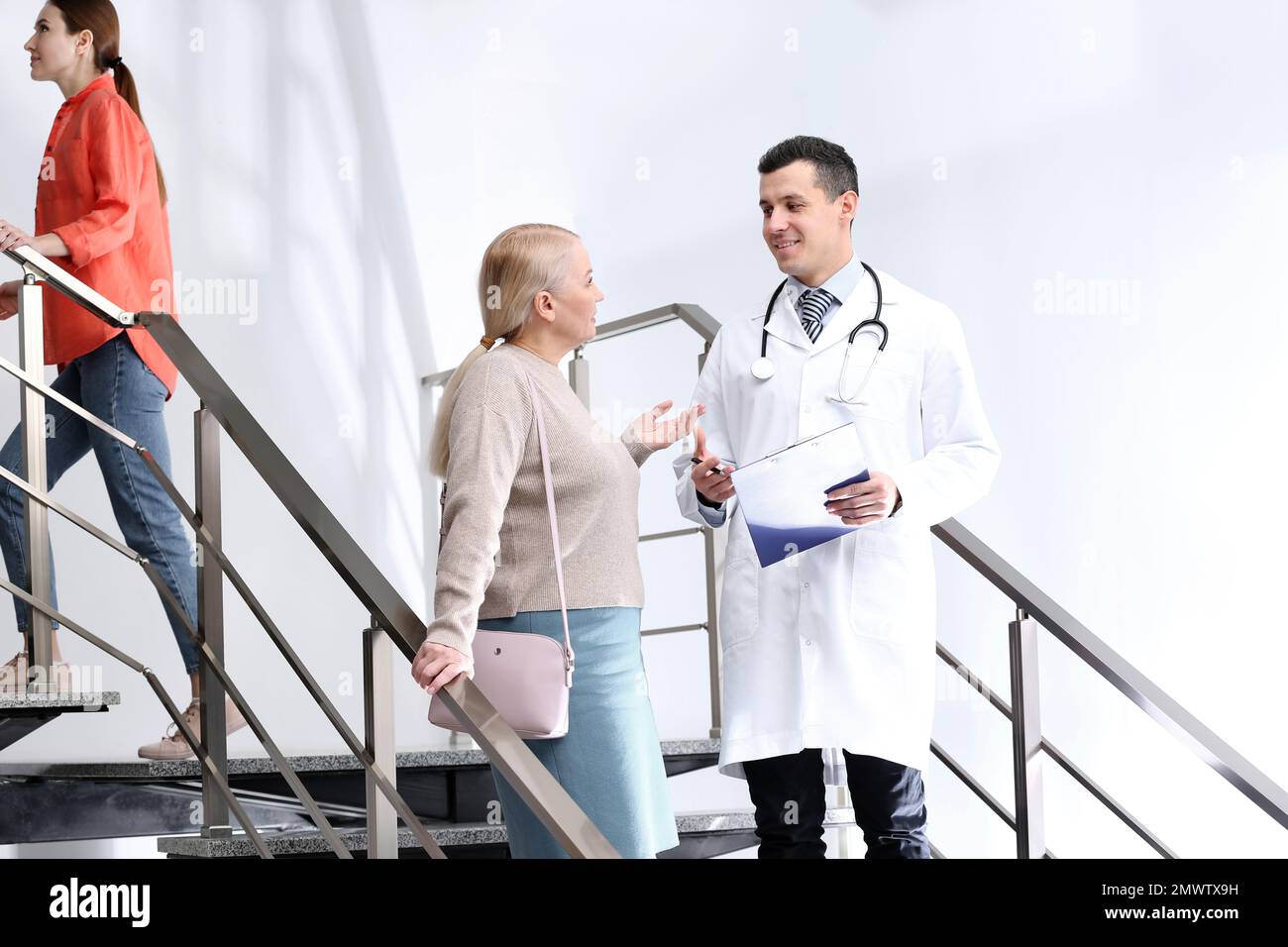 Doctor and patient discussing diagnosis on stairs in hospital Stock ...