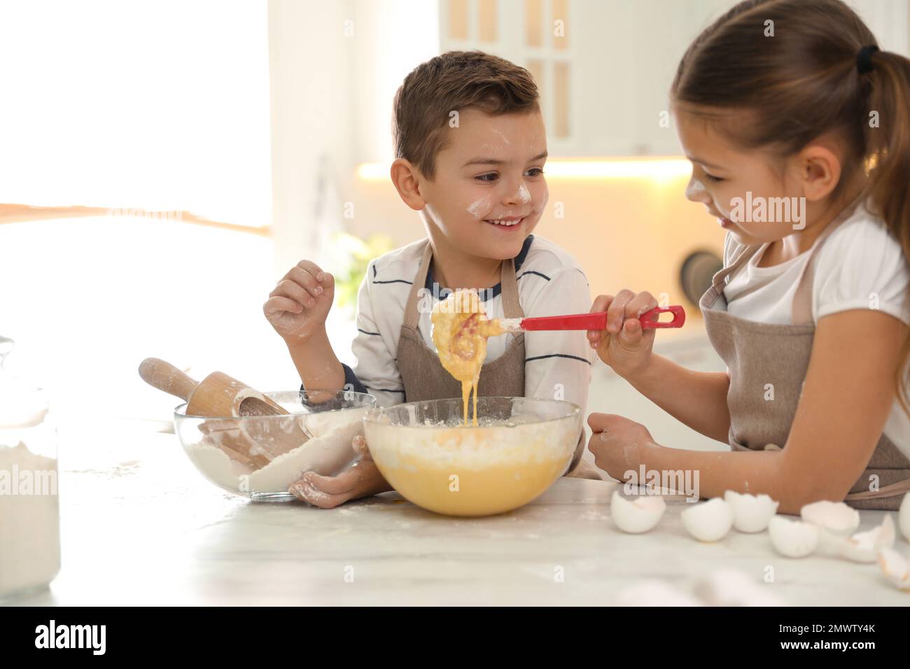 Cute little children cooking dough together in kitchen Stock Photo - Alamy