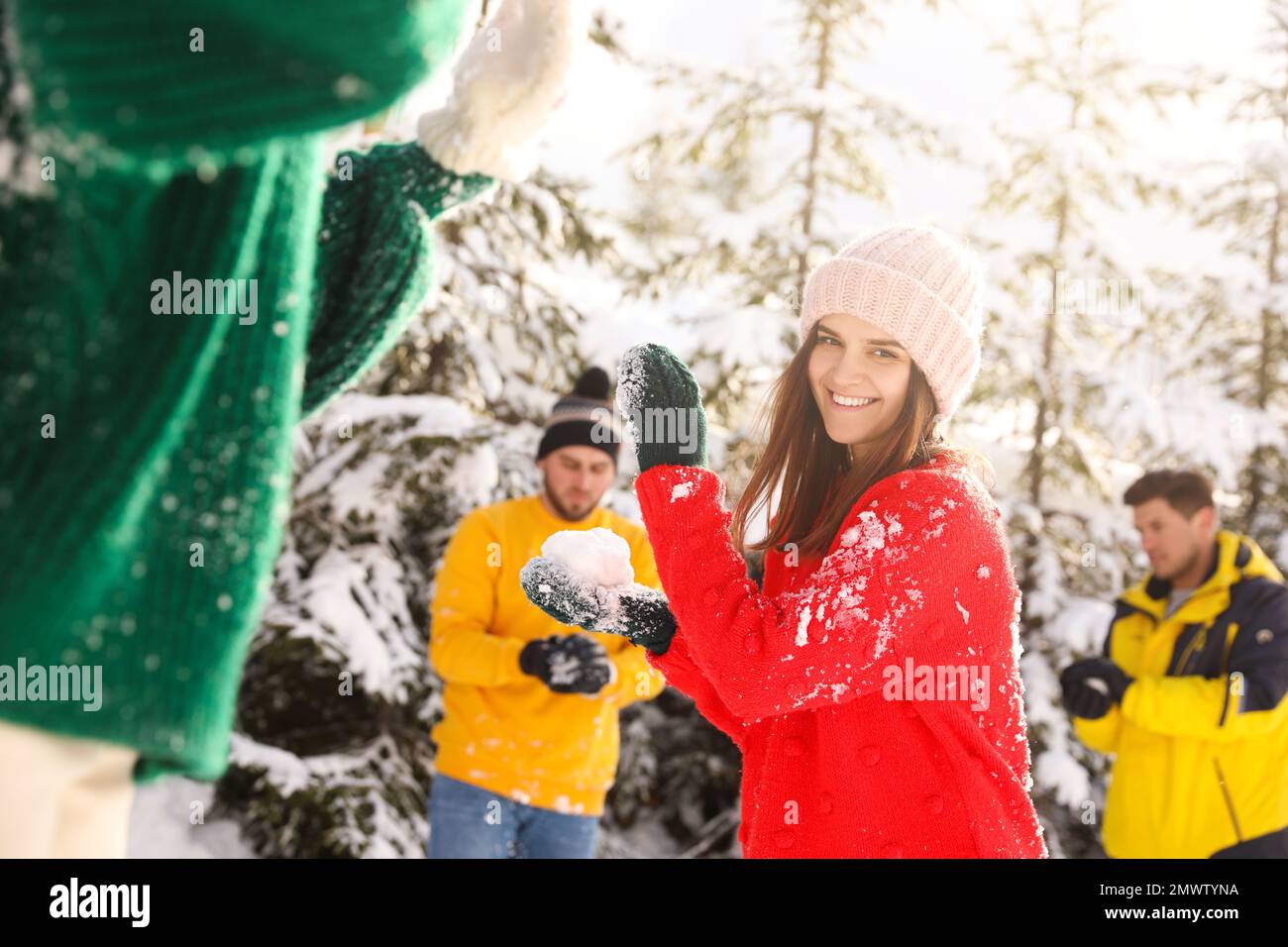 Happy friends playing snowballs outdoors. Winter vacation Stock Photo ...