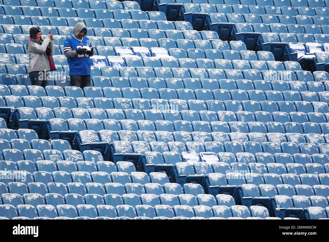 Spectators arrive as light snow covers seats prior to an NFL football ...