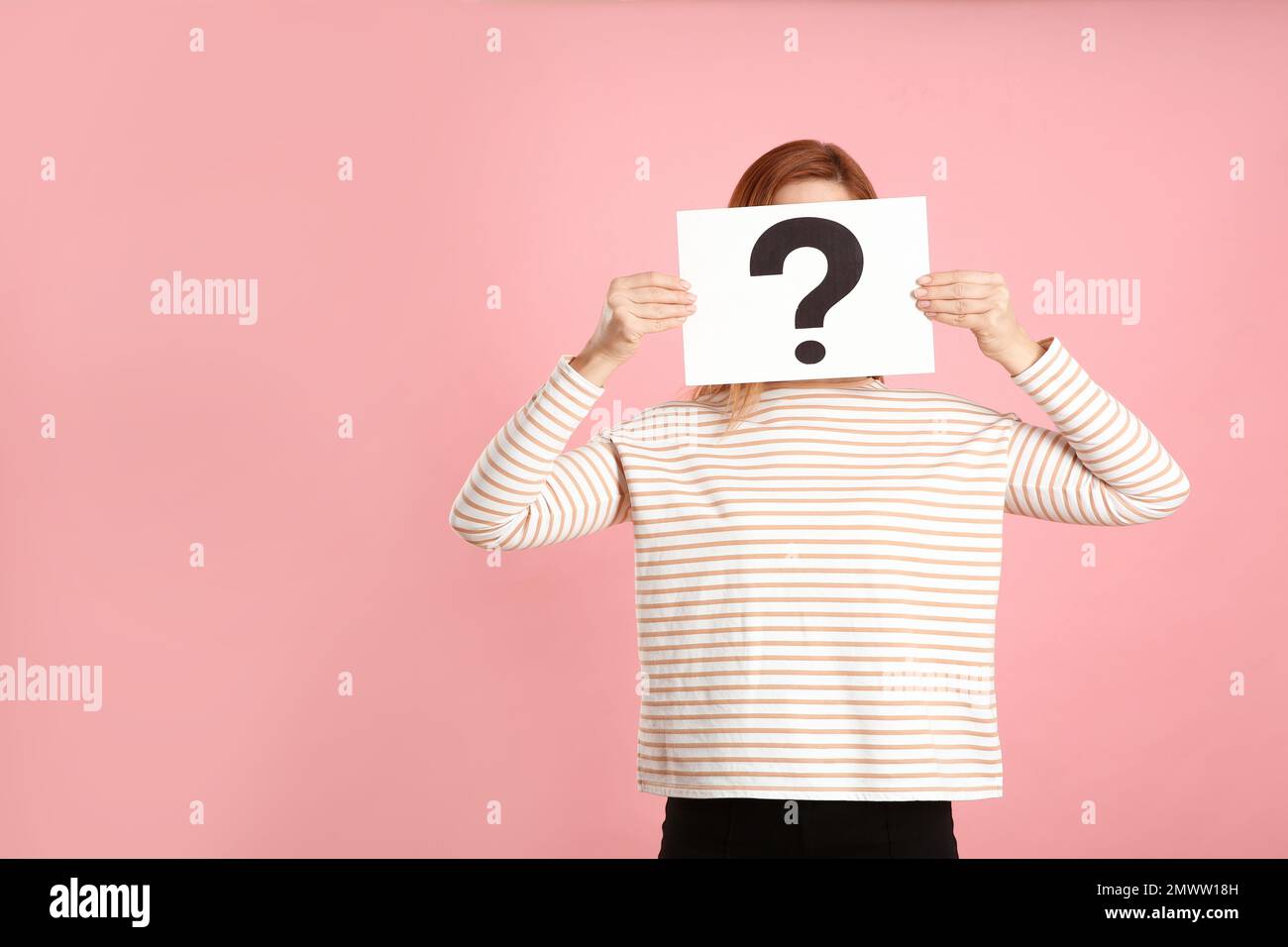Woman holding question mark sign on pink background. Space for text ...