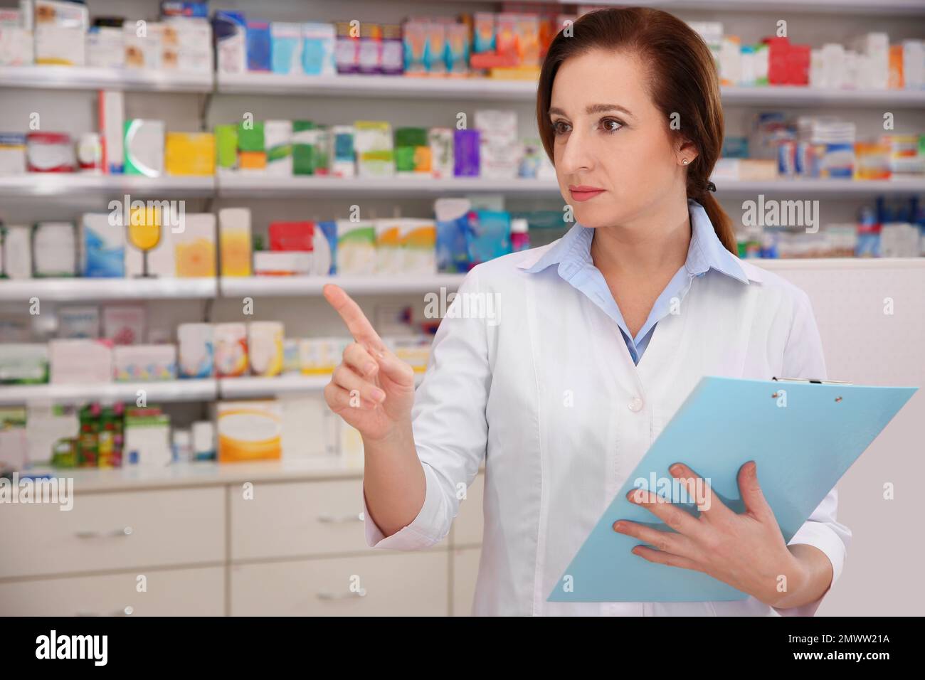 Professional pharmacist with clipboard in modern drugstore Stock Photo ...