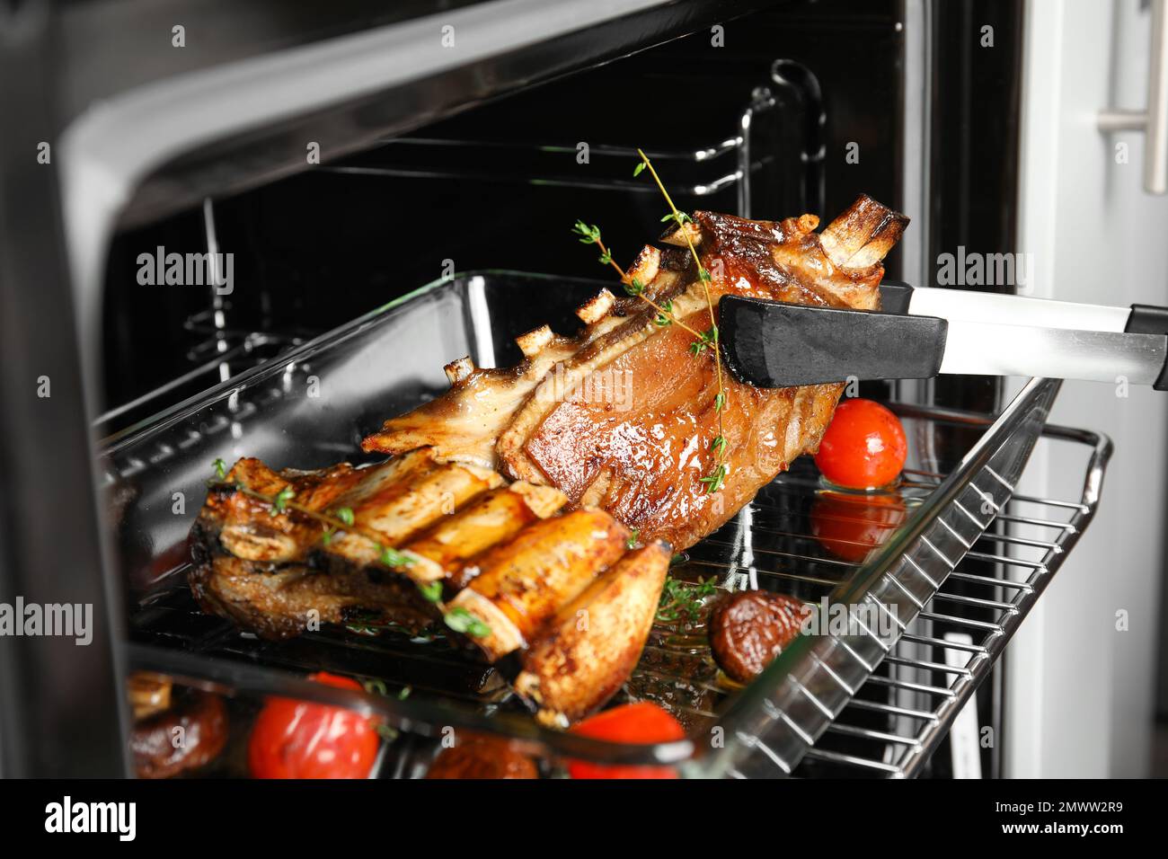 Delicious roasted ribs in oven, closeup. Yummy meat Stock Photo - Alamy