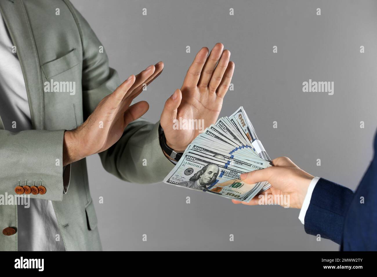 Man refusing to take bribe on grey background, closeup of hands Stock ...