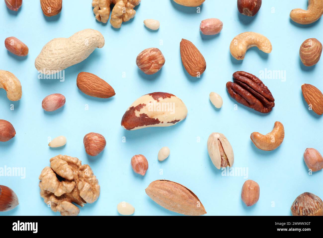 Different delicious nuts on light blue background, flat lay Stock Photo ...