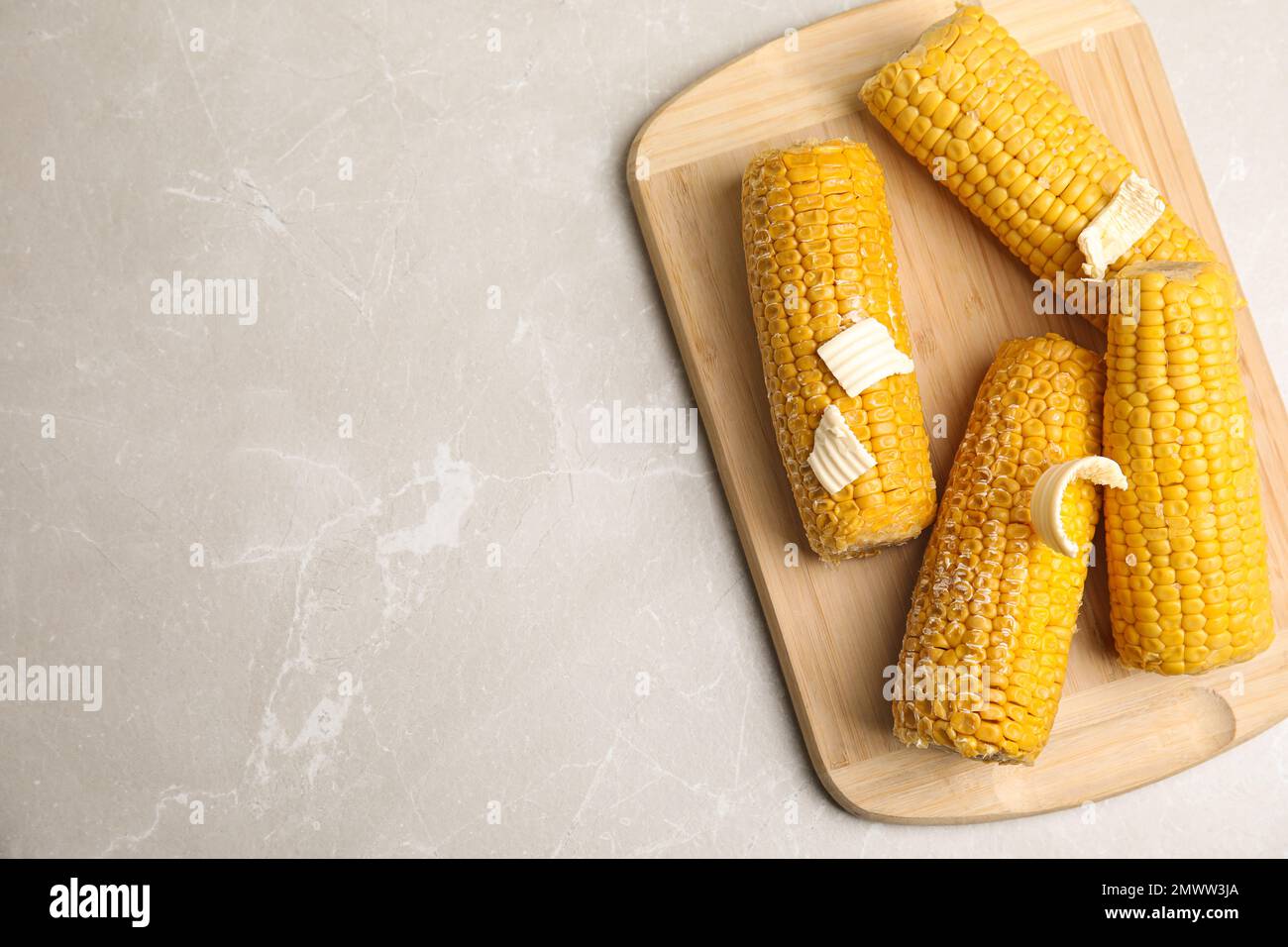 Delicious boiled corn on light grey marble table, top view. Space for ...