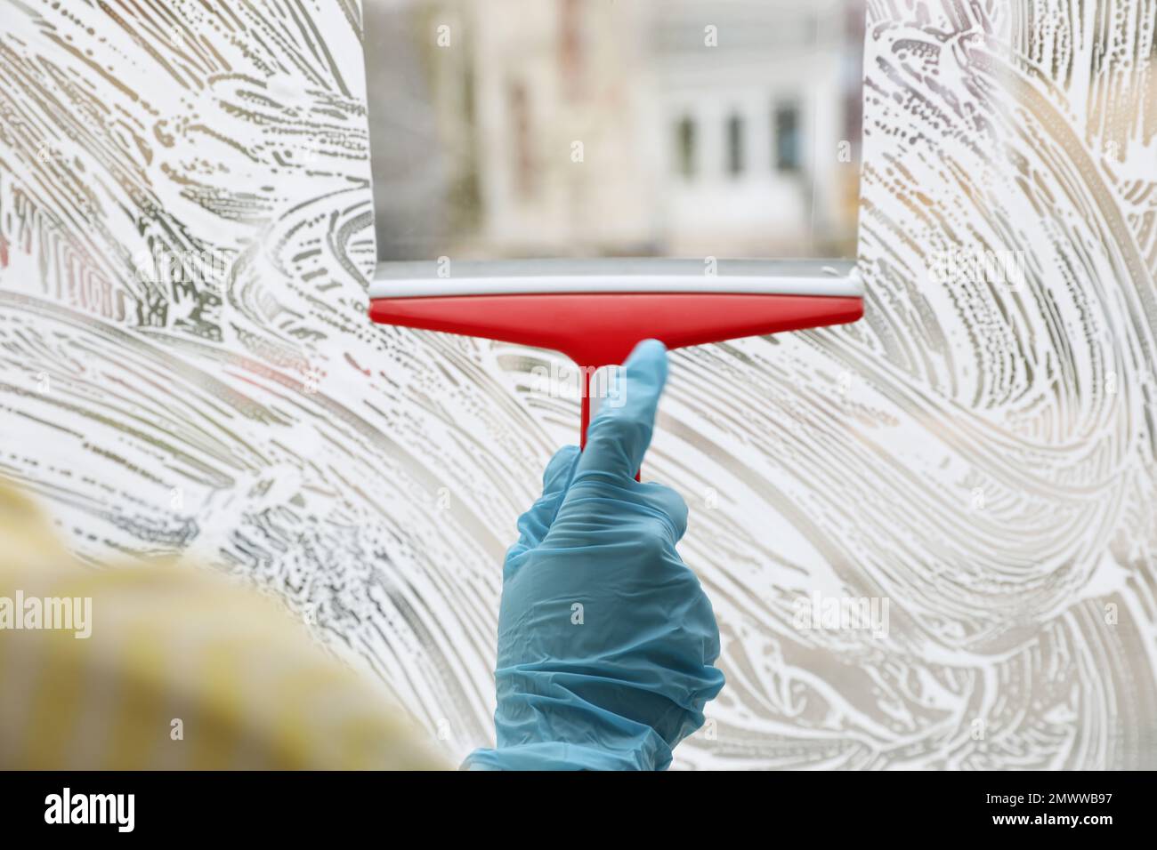 Woman cleaning window with squeegee indoors, closeup Stock Photo - Alamy