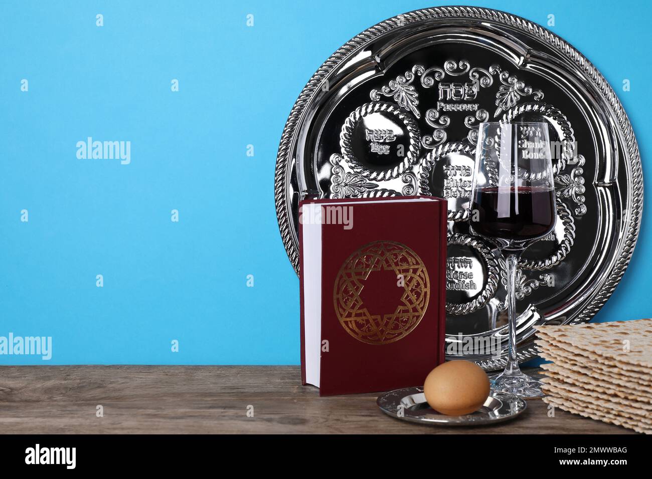 Symbolic Pesach (Passover Seder) items on wooden table against blue ...
