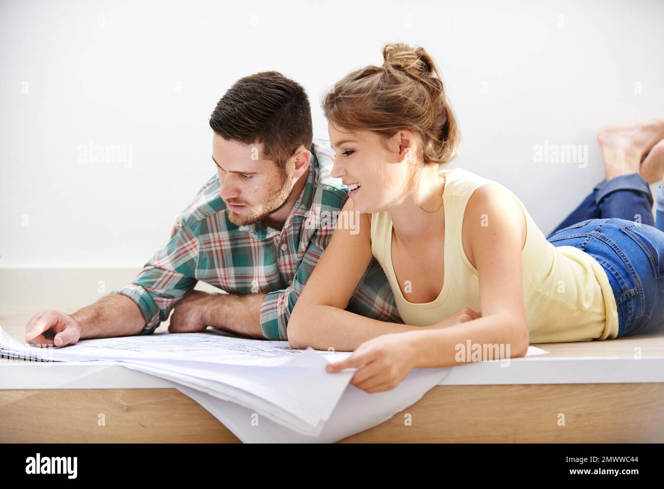 Planning for the future. a young couple inspecting the building plans ...