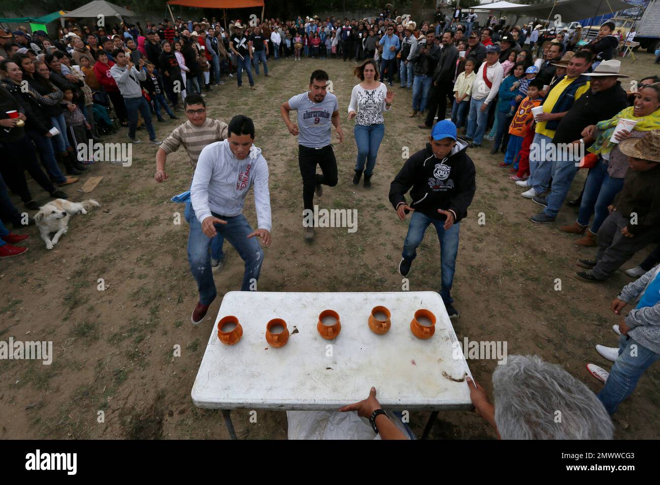 In this Nov. 20, 2016 photo, participants race to a table in a pulque ...