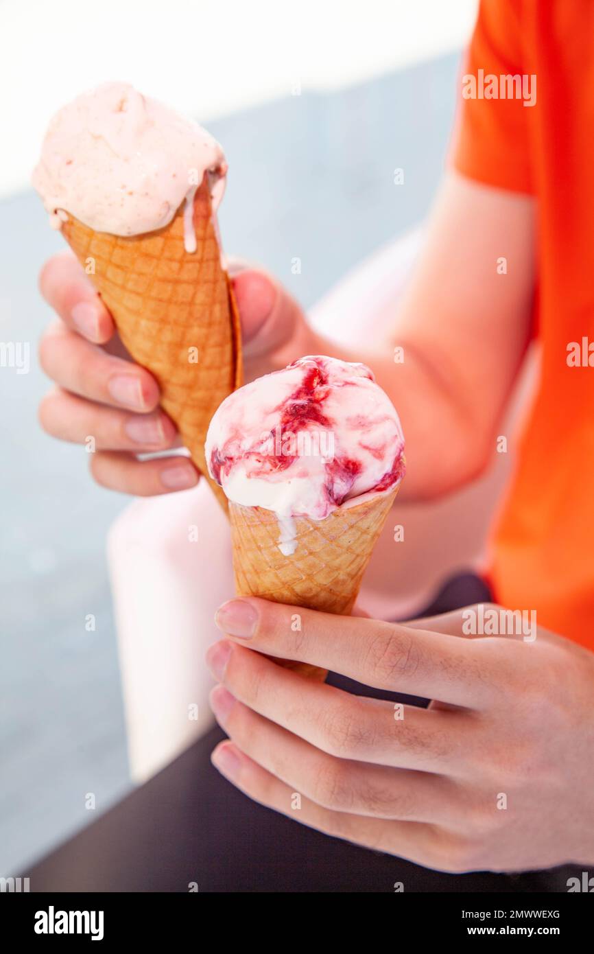 Hand holding gelato cone ice cream in two hands Stock Photo - Alamy