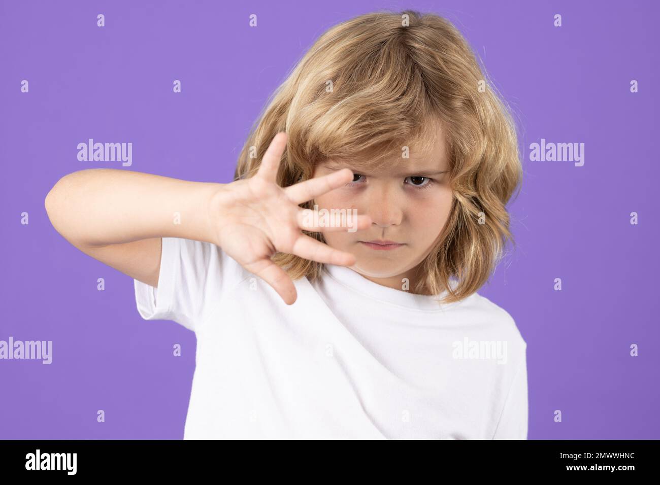 Portrait of kid boy making stop gesture on isolated studio background ...