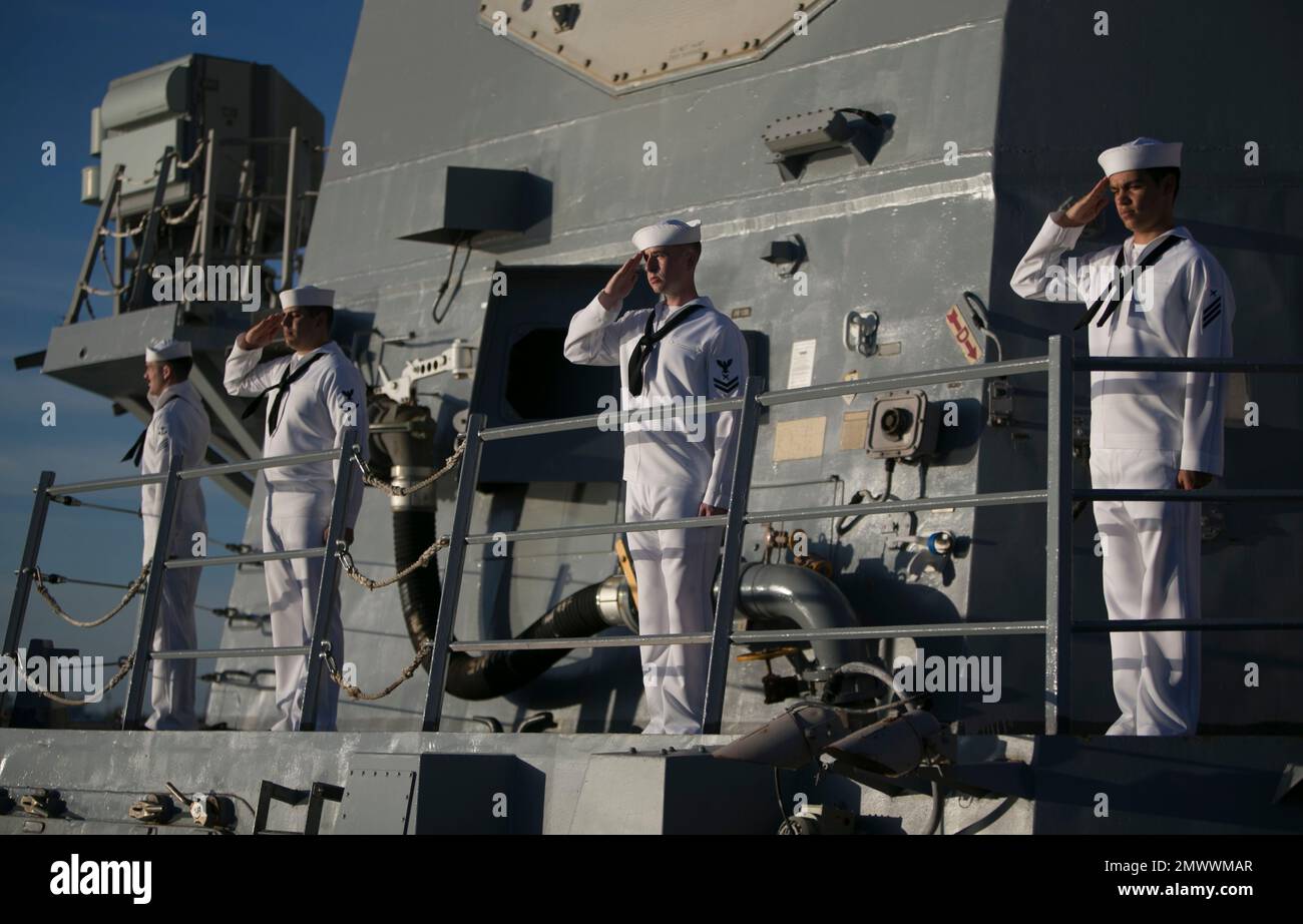 A Navy sailors aboard the USS Halsey salute the USS Utah Memorial ...