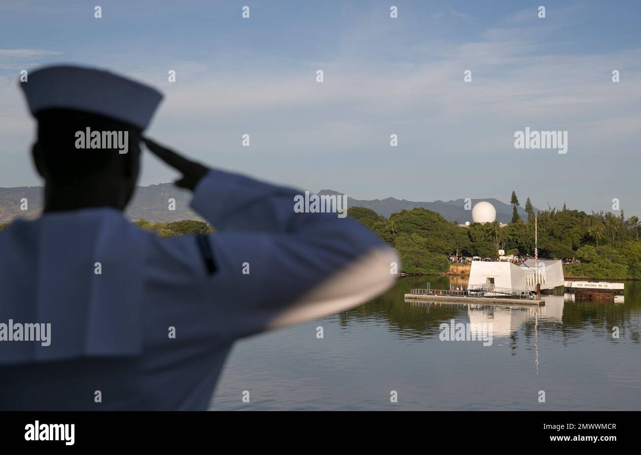 A Navy sailor salutes the USS Arizona memorial as the USS Halsey sails ...